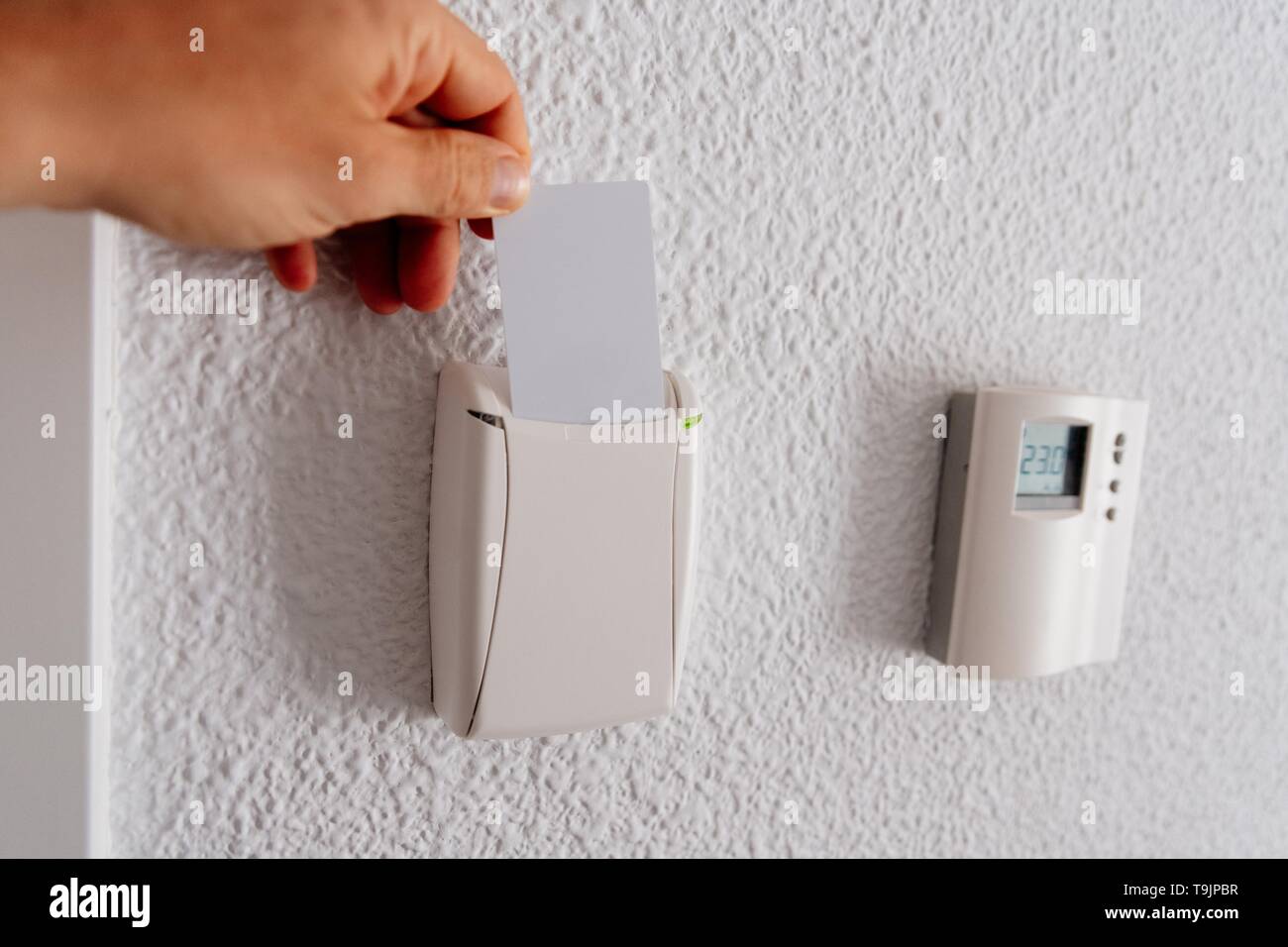 Man inserting electronic hotel key card to holder Stock Photo - Alamy