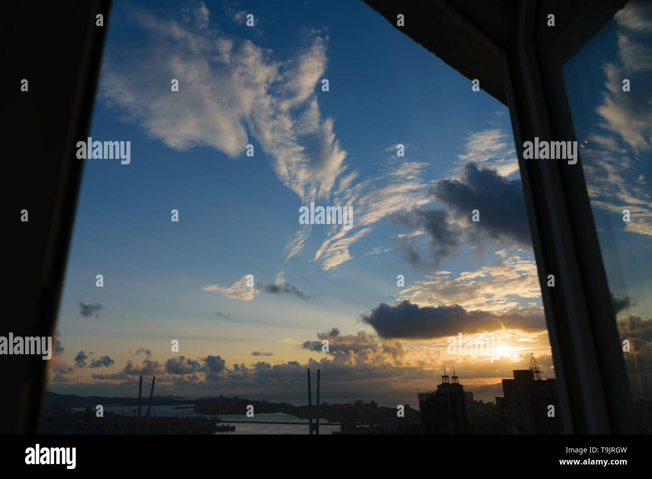 Sunset sky over city - view from window Stock Photo - Alamy
