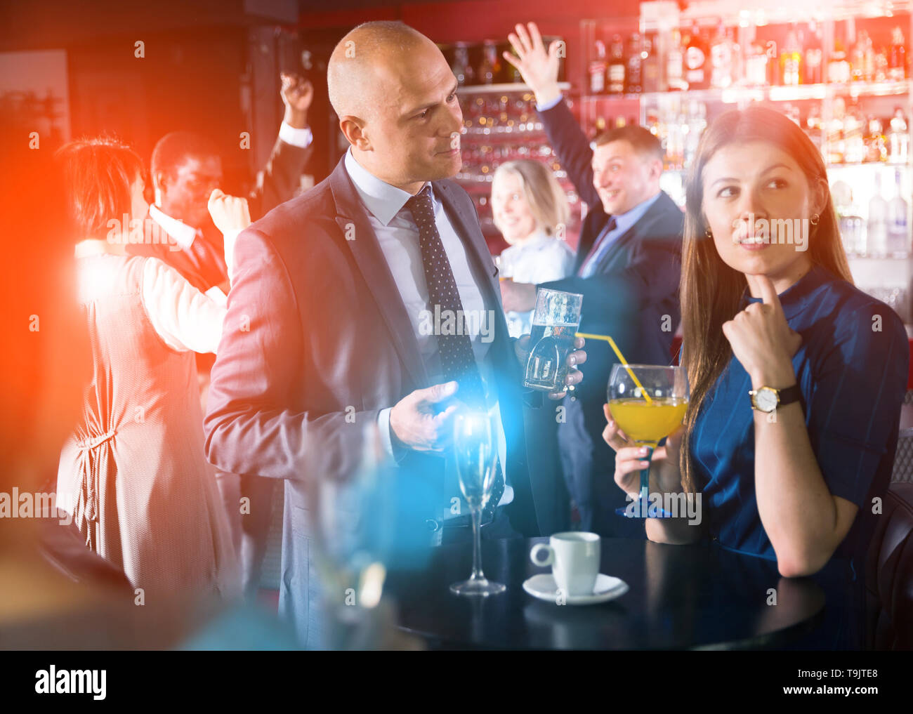 Portrait of man having fun and talking to woman on corporate party ...