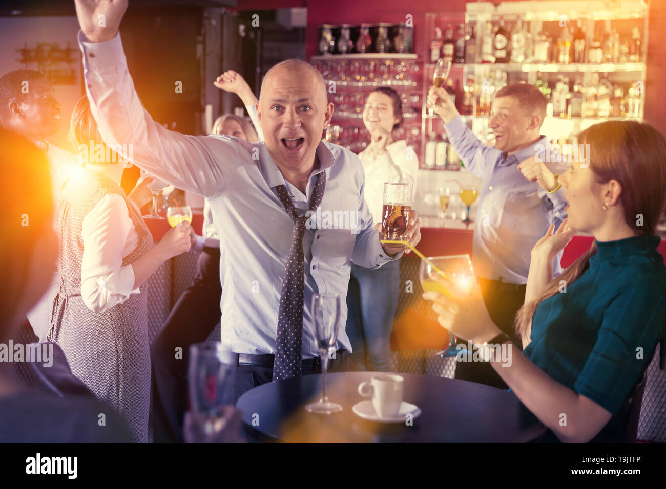 Portrait of cheerful tipsy businessman drinking alcohol and having fun ...