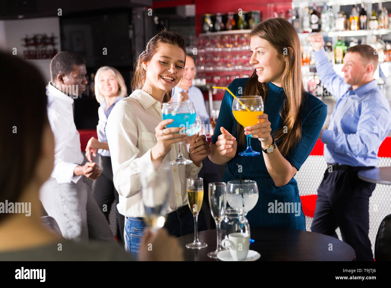 Portrait of two girls having fun and talking on corporate party Stock ...