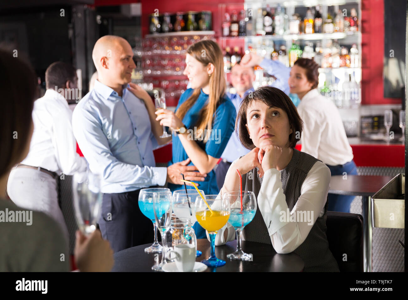Portrait of sad woman bored at corporate party Stock Photo - Alamy