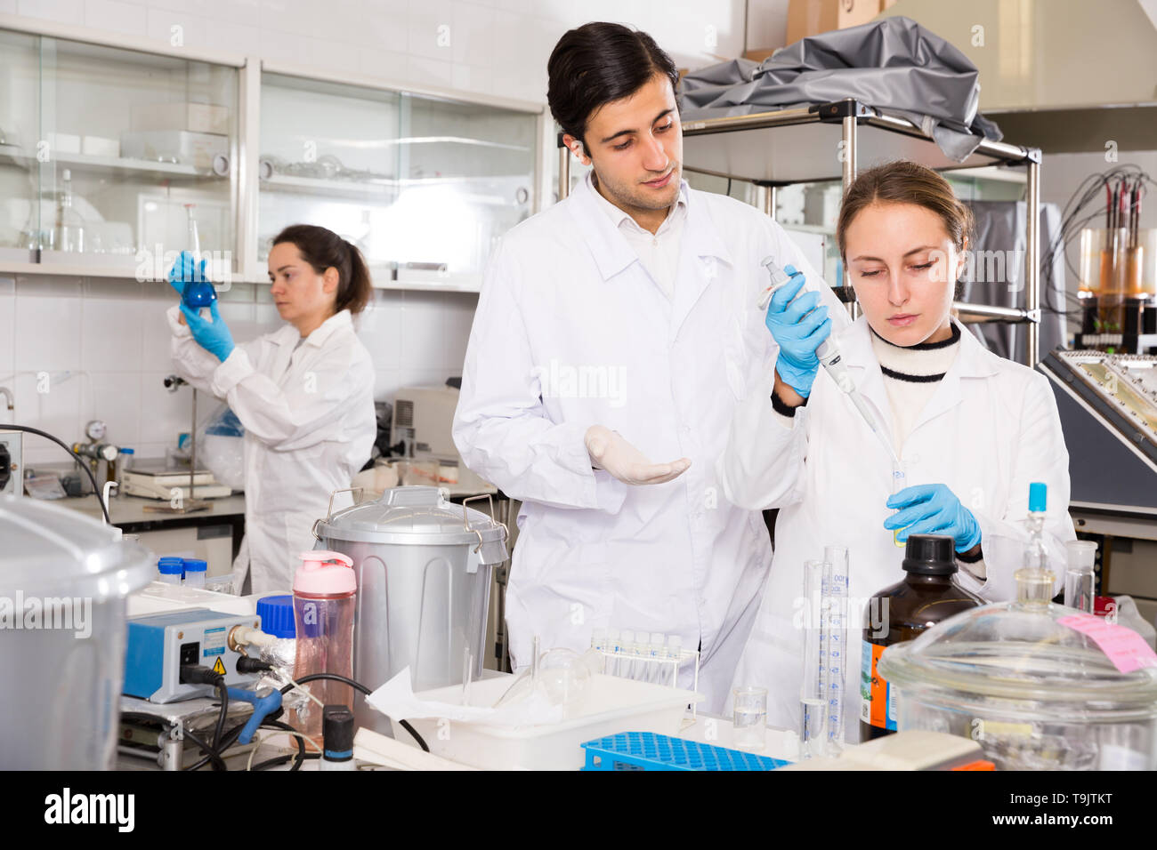 Two students performing experiments in university laboratory, using ...