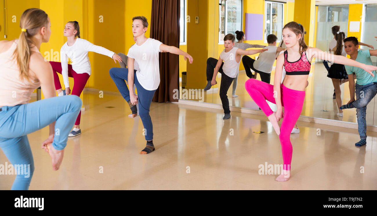 Group of children participating in dance class, following their teacher ...