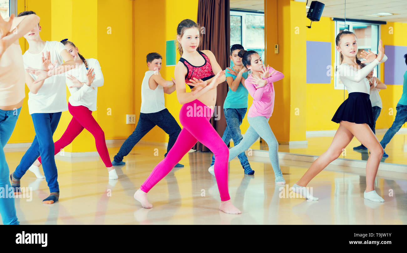 Group of children participating in dance class, following their teacher ...