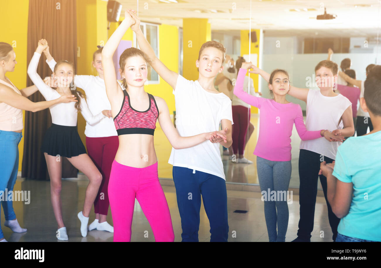 Group of tweens practicing vigorous jive movements in choreography ...