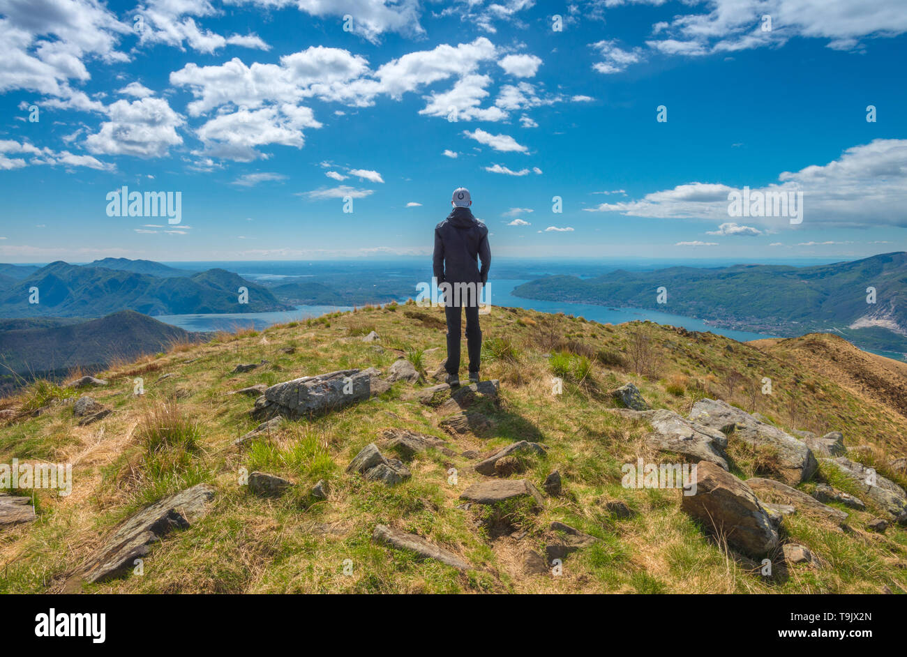 Lonely man, lone male hiker looks at Lake Maggiore from the summit of a ...