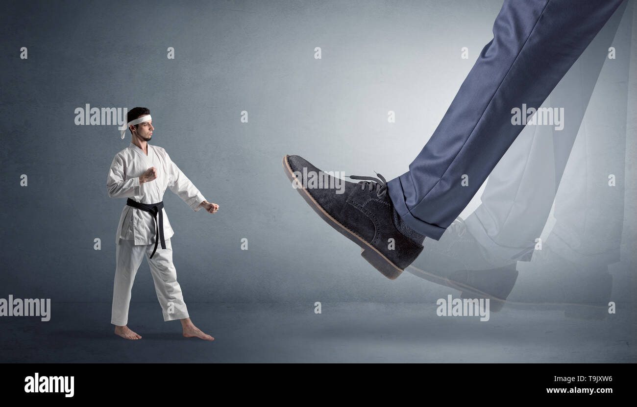 Big foot treading small young karate man Stock Photo - Alamy