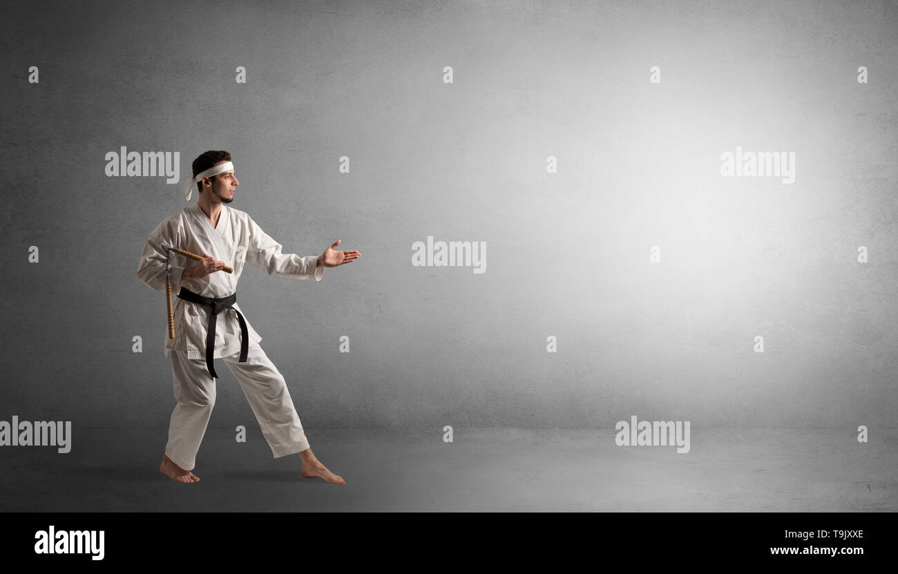 Small karate man fighting in an empty grey copy space Stock Photo - Alamy