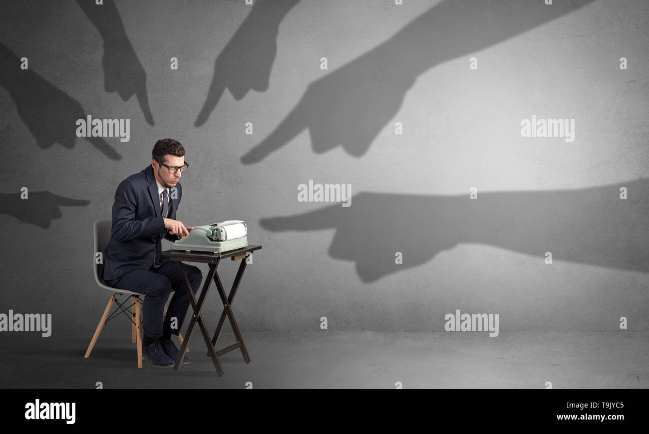 Shadow hand pointing at a small afraid worker Stock Photo - Alamy