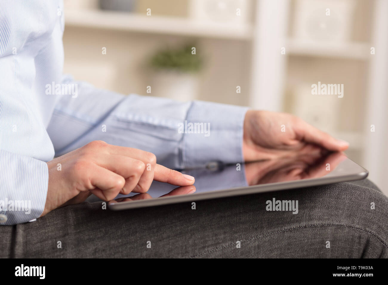 Business woman below chest using tablet in a homey environment Stock ...