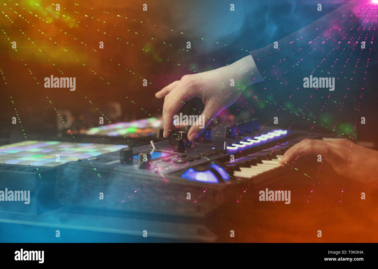 Hand mixing music on midi controller with party club colors around ...