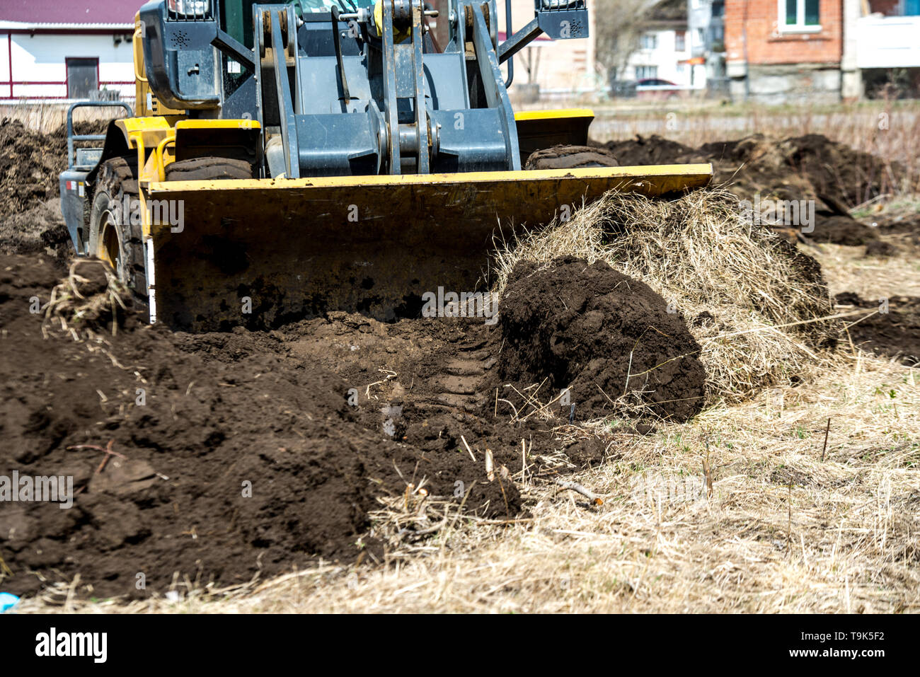 bulldozer pushes the ground, tractor pushes a lump of soil, preparing ...