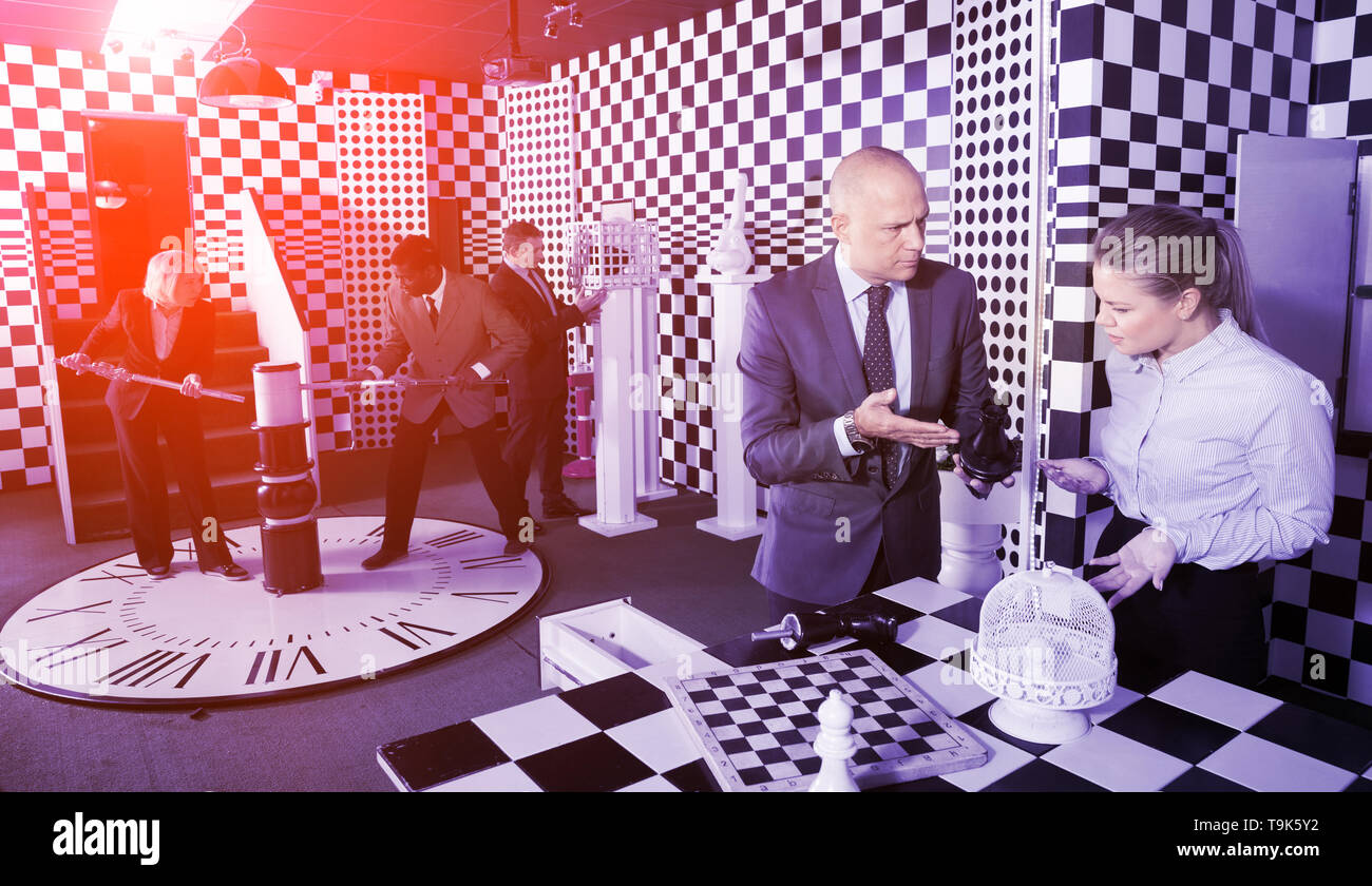 Men and women in business suits solving puzzles with chess to get out ...