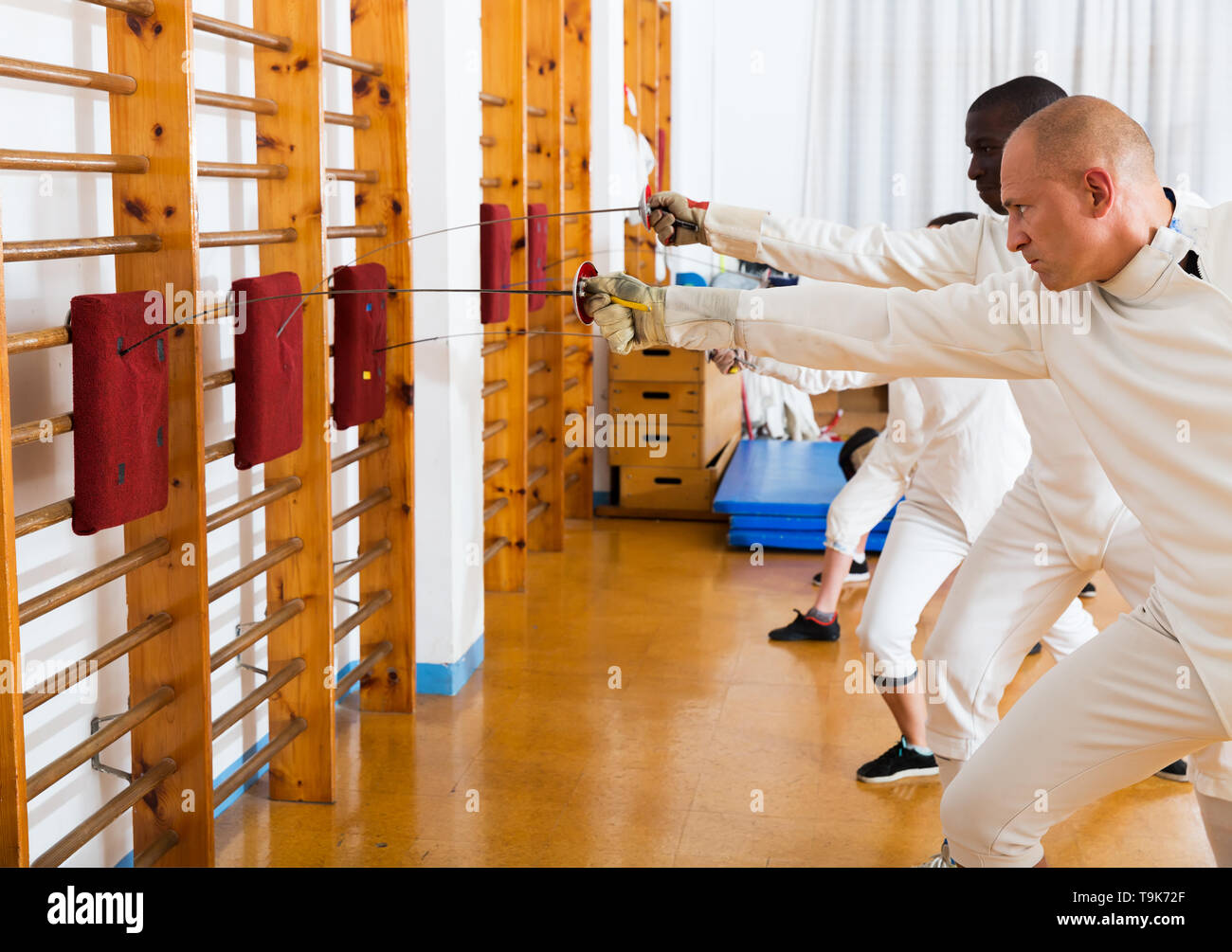 Children with adults practicing effective techniques of fencing in ...
