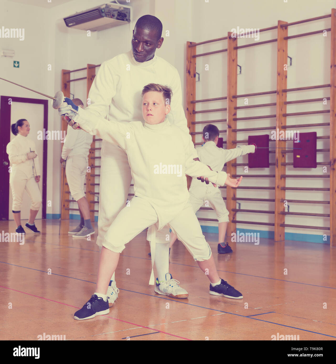 Fencing instructor explaining to young fencers an effective movements ...