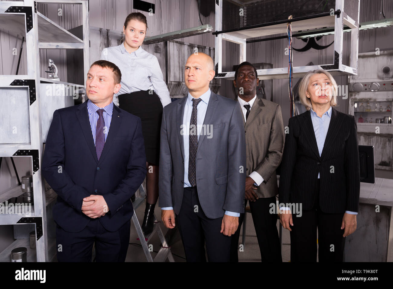 Men and women in pensive poses standing in quest room Stock Photo - Alamy