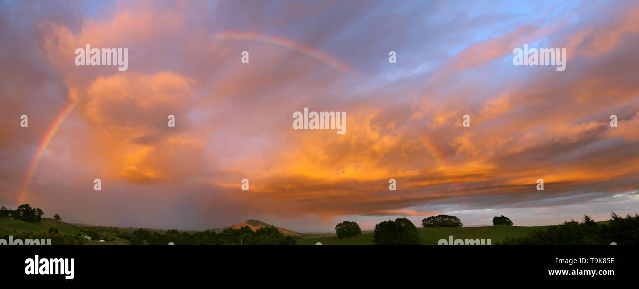 Rainbow in sunset sky over New Zealand landscape Stock Photo - Alamy