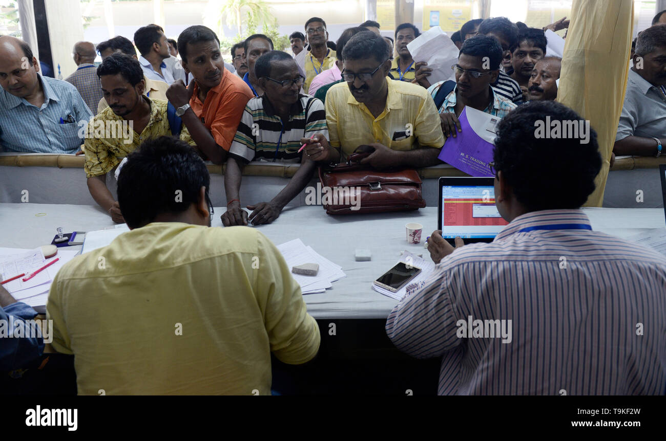 Kolkata, India. 18th May, 2019. Polling officials queue at counter to ...