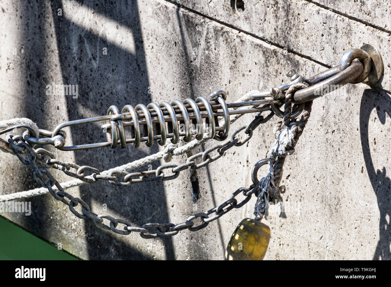 Close Up of marina mooring with shock-absorbing springs, ropes and ...