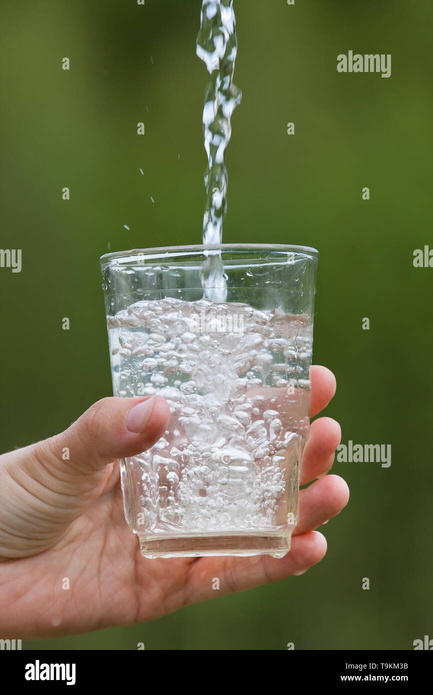 Hand pouring fresh water glass hi-res stock photography and images - Alamy
