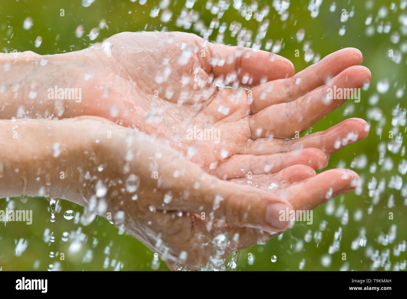 hands of woman catching raindrops on blurred background Stock Photo - Alamy