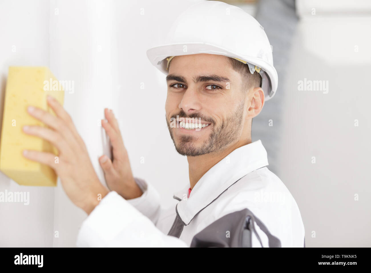 young plasterer finishing wall with sponge float panorama Stock Photo ...