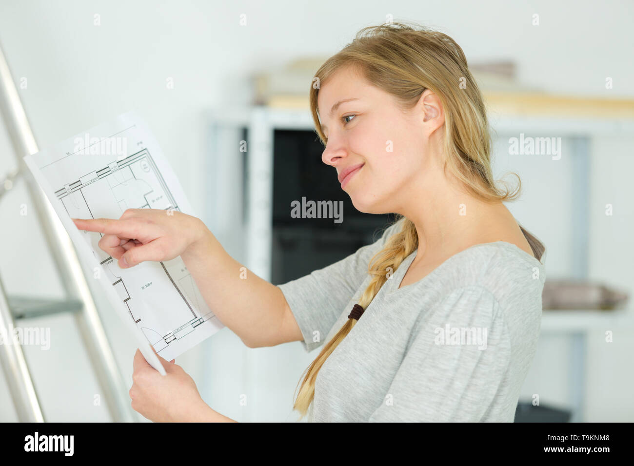 female interior designer looking at layout plans Stock Photo - Alamy