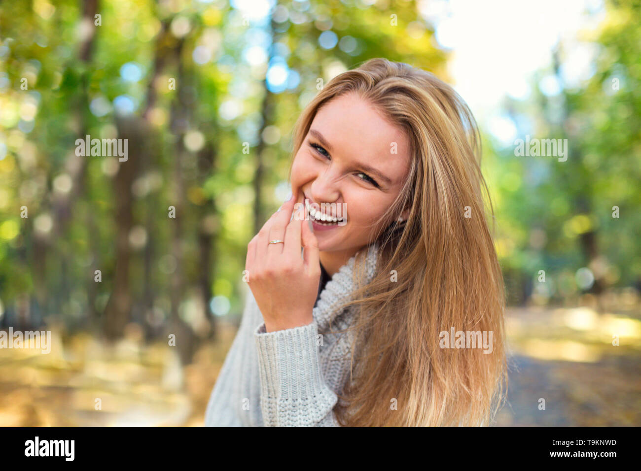 Happy blond girl posing in autumn park on yellow trees background Stock ...
