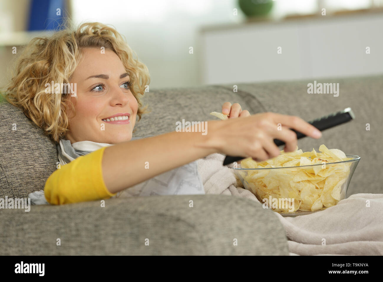 woman spends his free time watching tv on the couch Stock Photo - Alamy