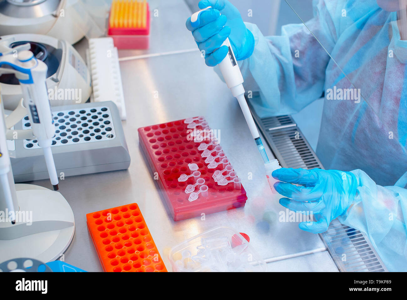 Dna test in the lab. a laboratory technician with a dispenser in his ...