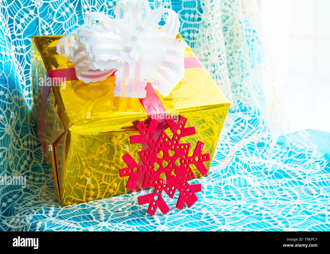 Gift box in gold foil package and red snowflake beautiful blue ...