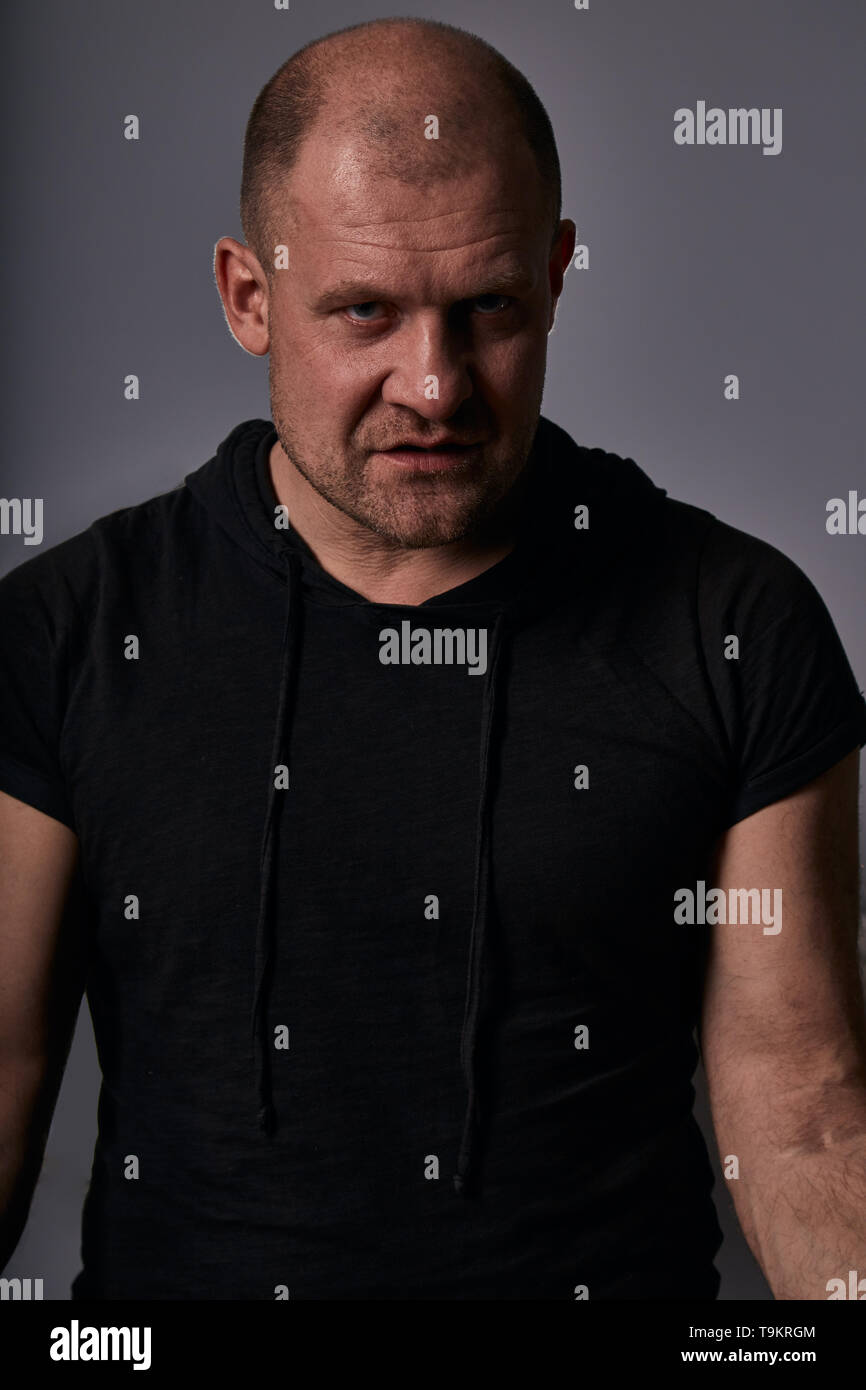 Sad angry crime man with bald head looking mystery and agressive in ...