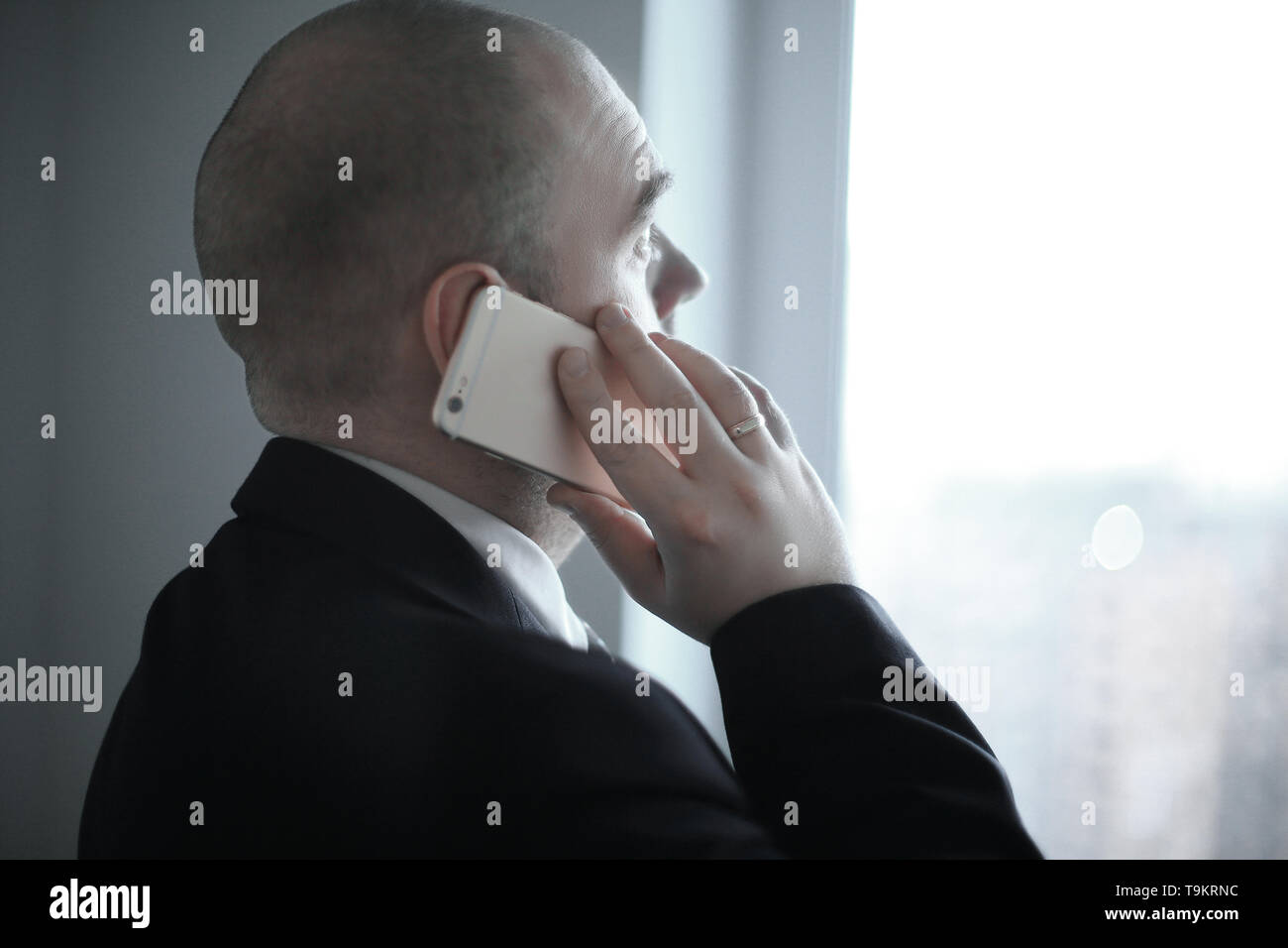 rear view .businessman with smartphone looking out the window of the ...