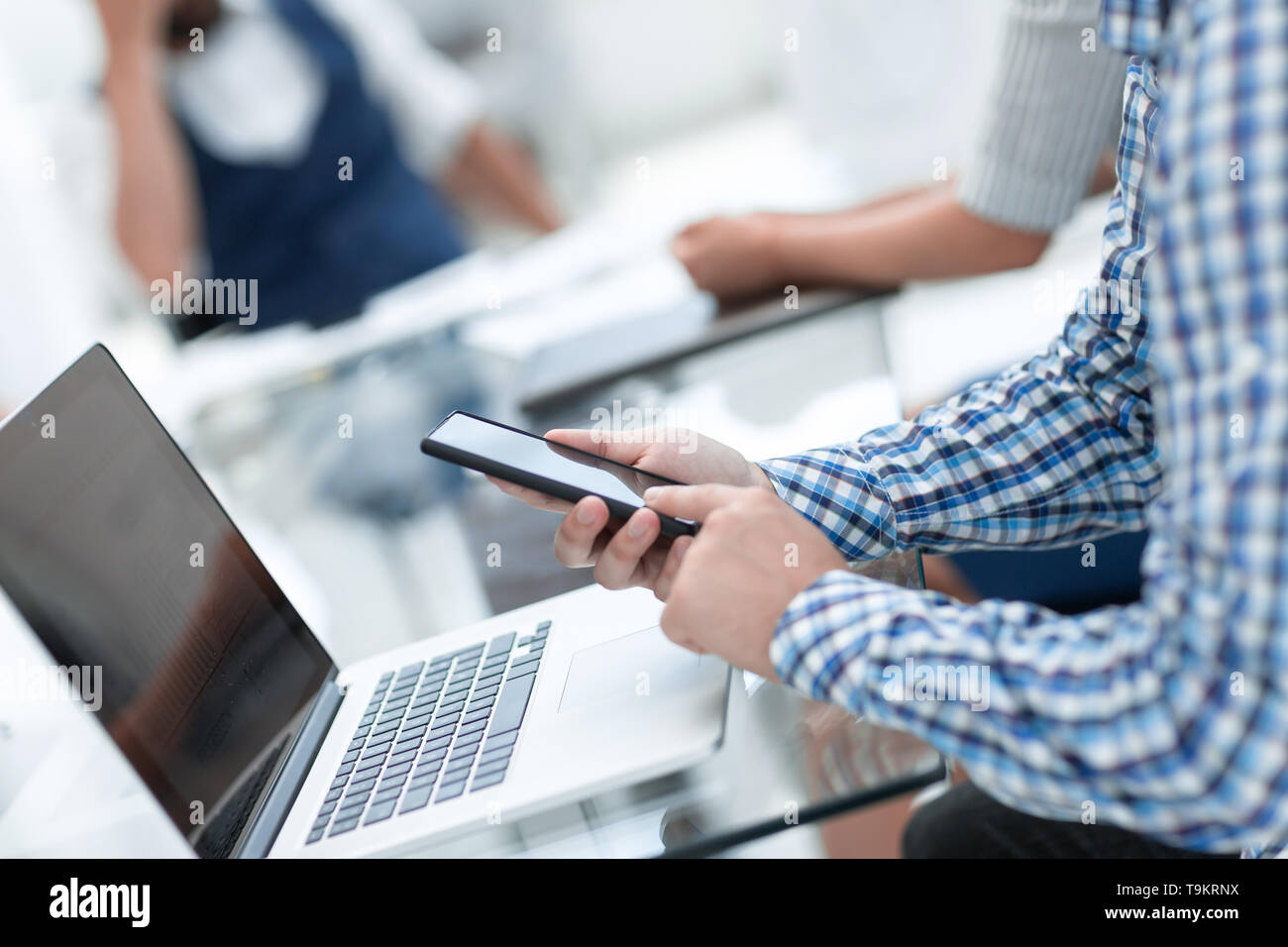 close up.a business man uses a smartphone sitting at his Desk. people ...