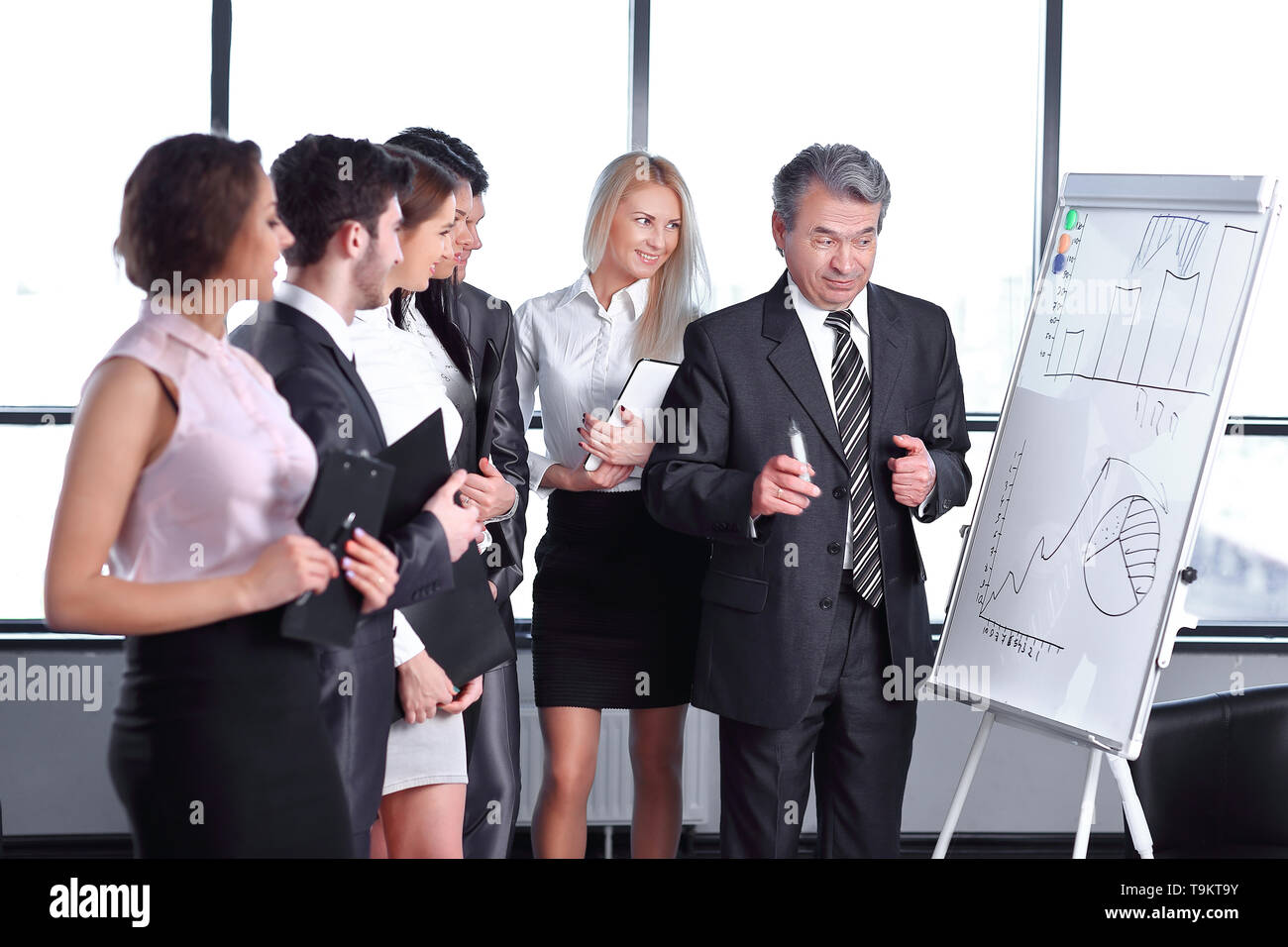 A group of business people looking at the chart on the flipchart. start ...