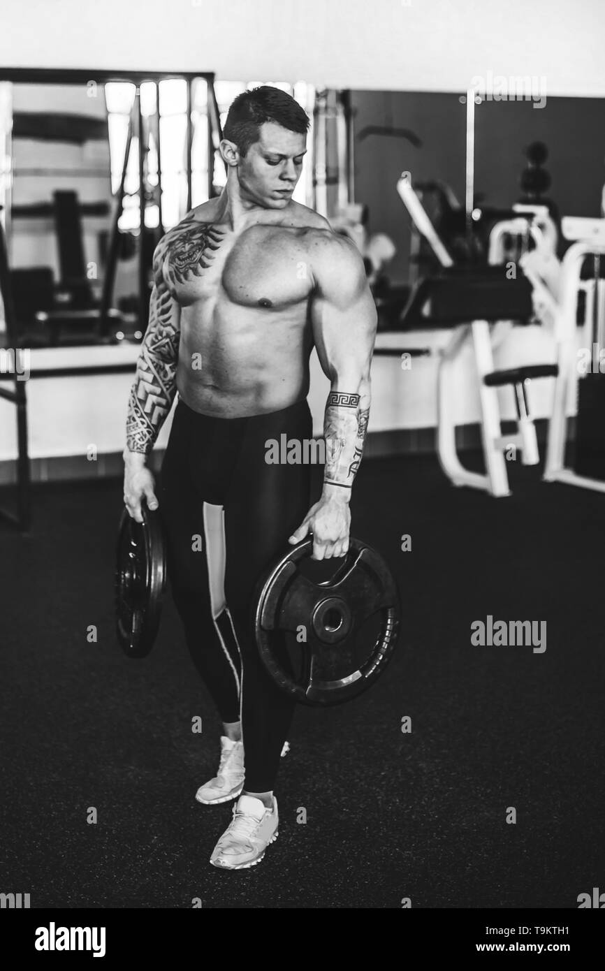 confident young bodybuilder standing in a modern gym. sport and health ...