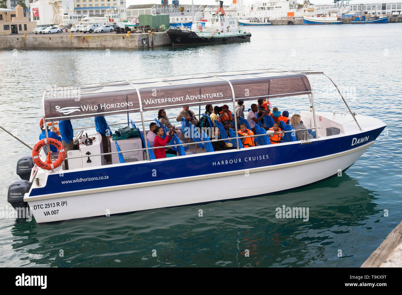 Waterfront harbour cruise boat and tourists on board on a sightseeing ...