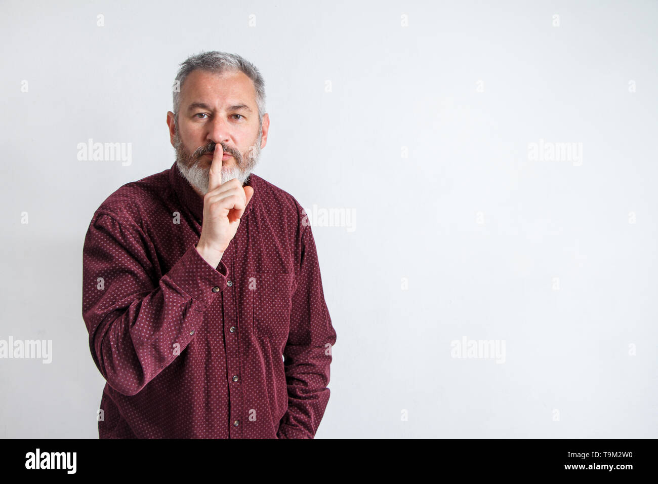 gray bearded man have the finger on lips as man gesturing shh sign ...