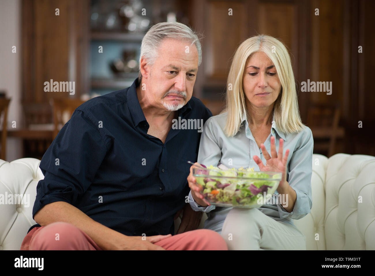 Disgusted couple eating salad Stock Photo - Alamy