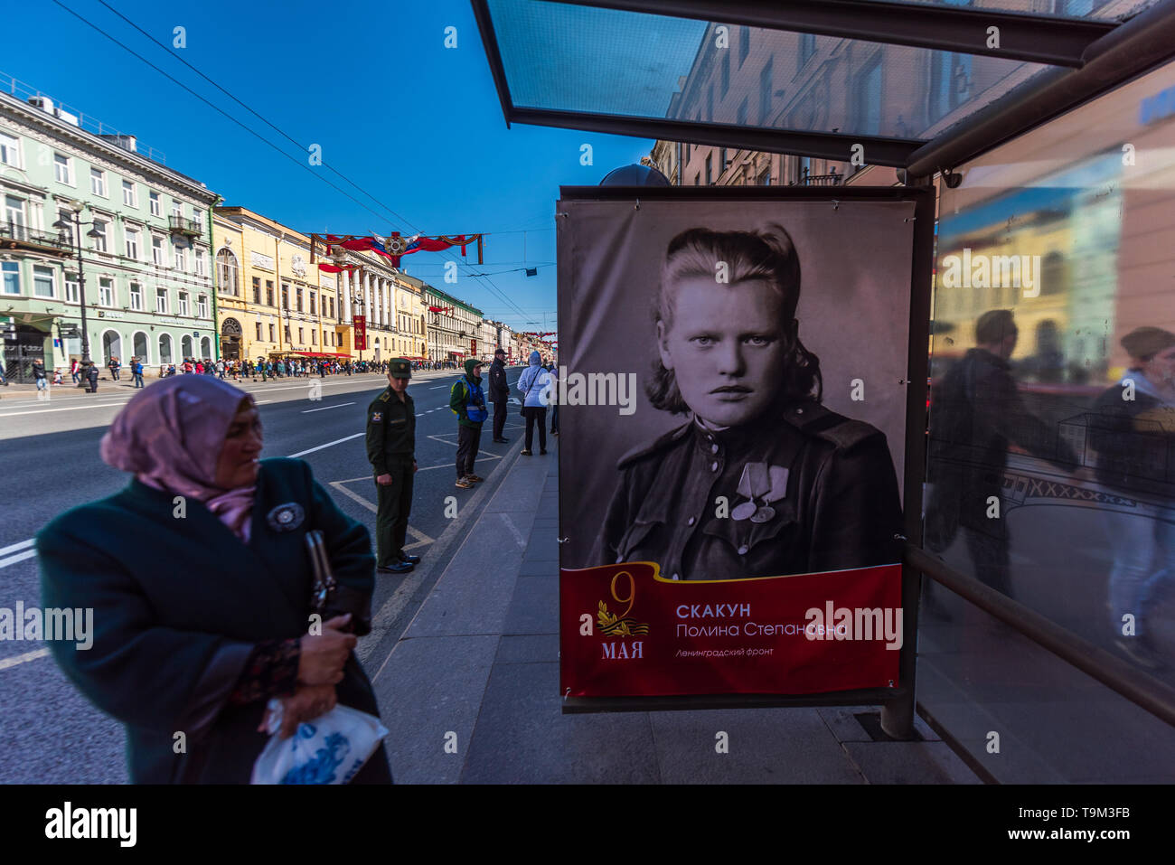 Russian woman looking a poster of vintage photo memorial in the parade ...