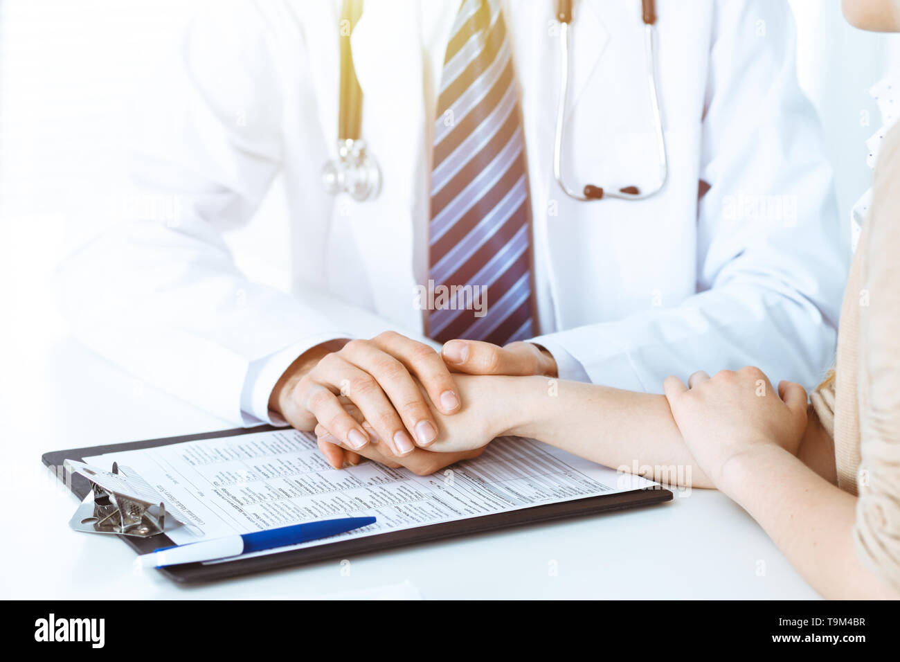Hand of doctor reassuring her female patient. Concepts of medical ...