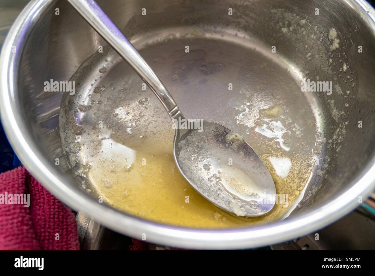 silver bowl with melted butter and a big spoon for baking and cooking ...
