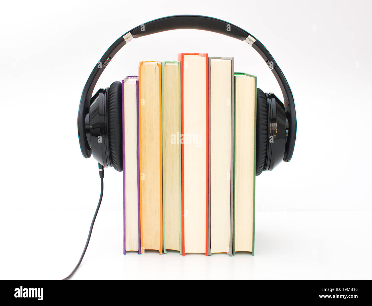 Audiobooks concept. Headphones put over book and white background ...