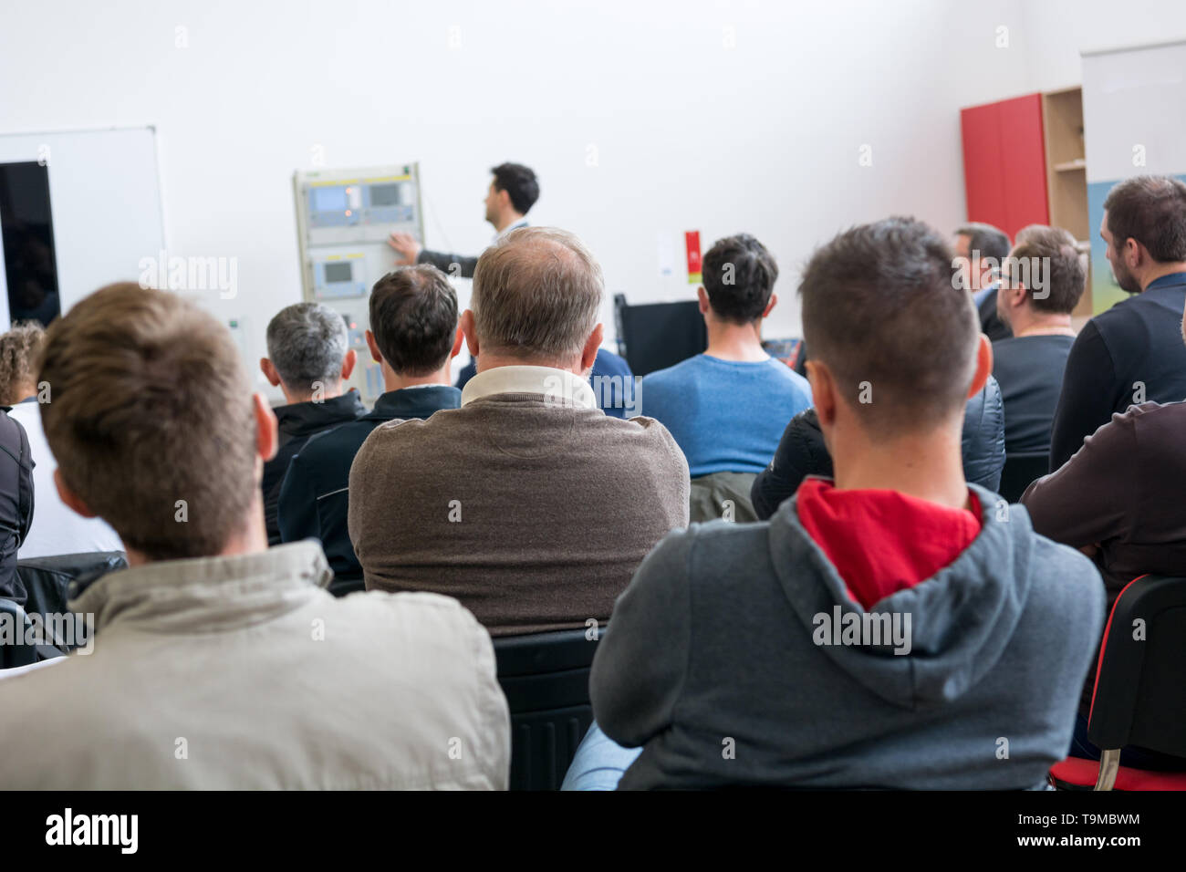 Audience at business presentation listening to person giving a speach ...