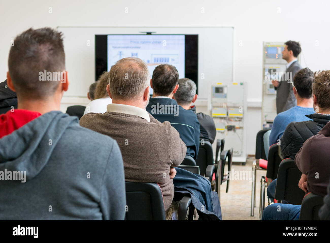 Audience at business presentation listening to person giving a speach ...