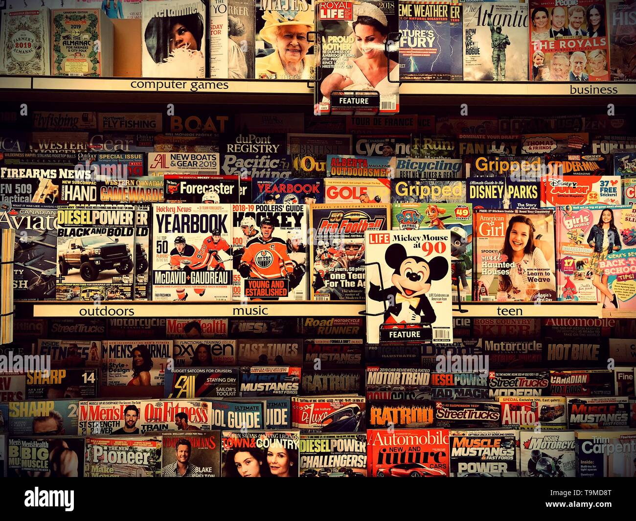 A magazine stand in a supermarket displaying Mickey Mouse in primary ...