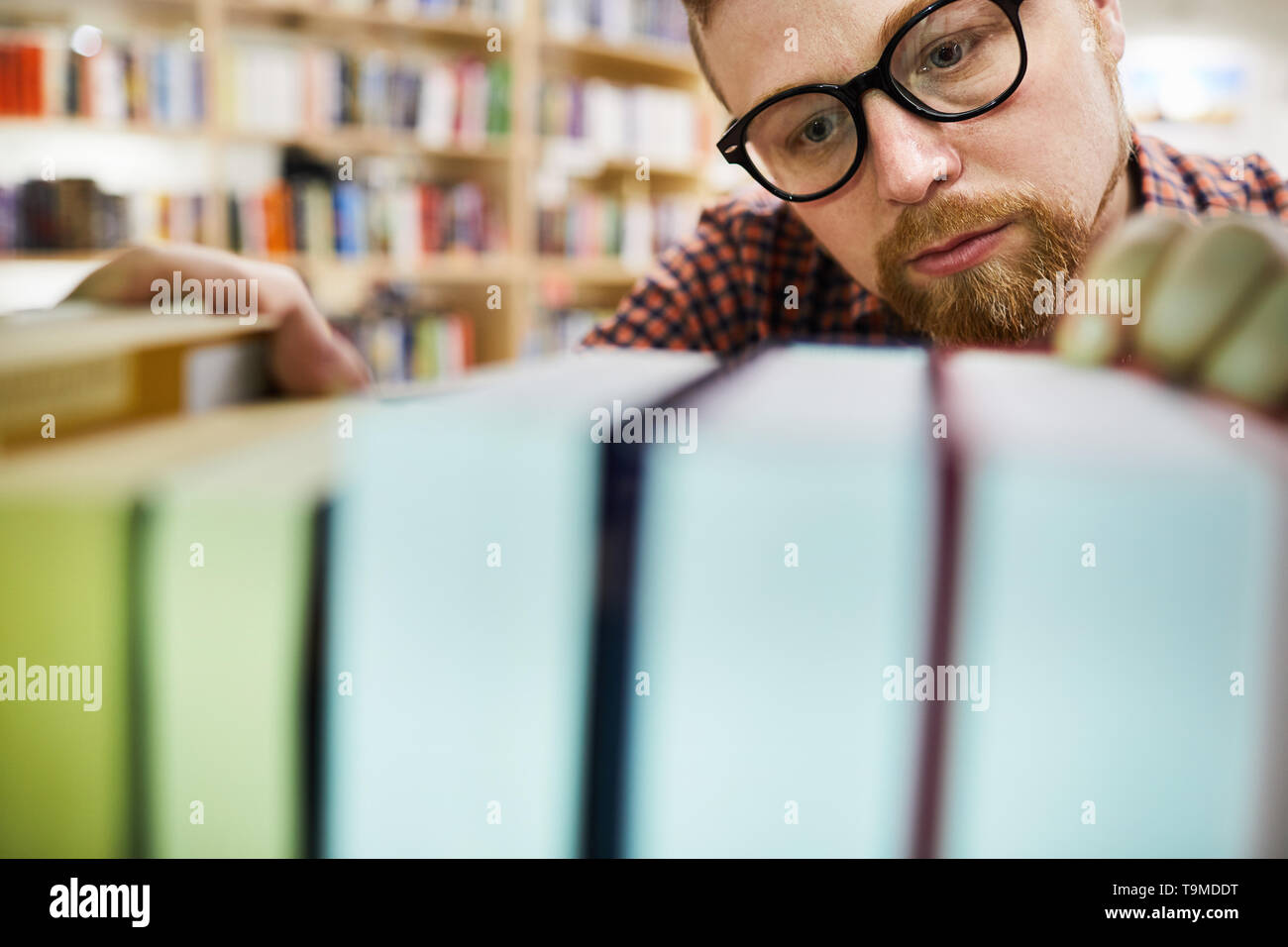Concentrated librarian finding book Stock Photo - Alamy