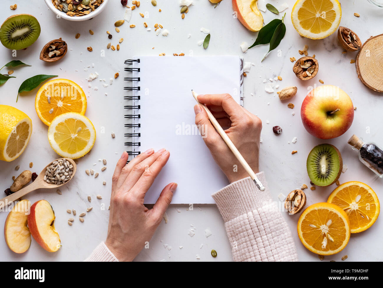 Female hand write in notebook on healthy food background, women diet ...