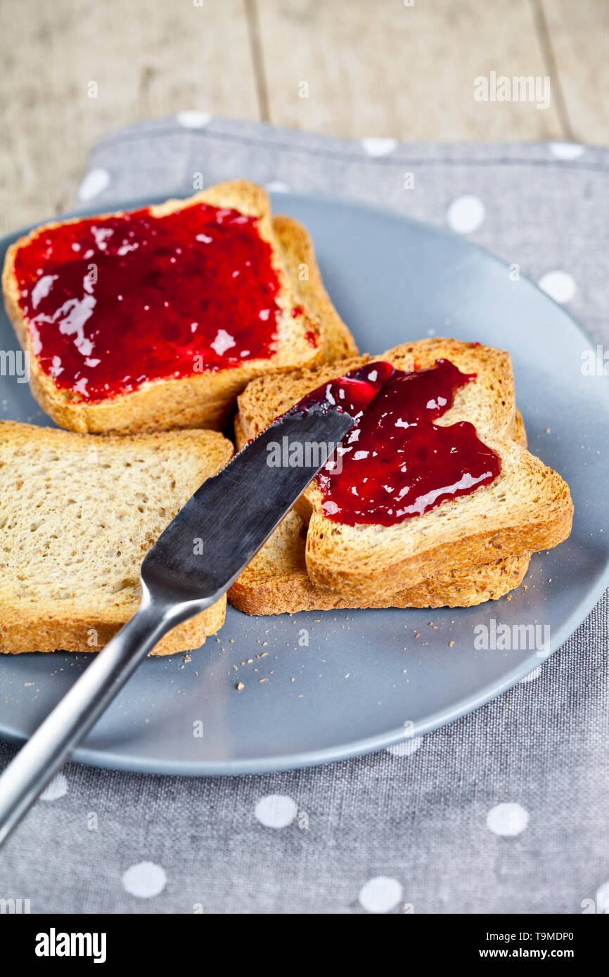 Fresh toasted cereal bread slices with homemade cherry jam and knife on ...